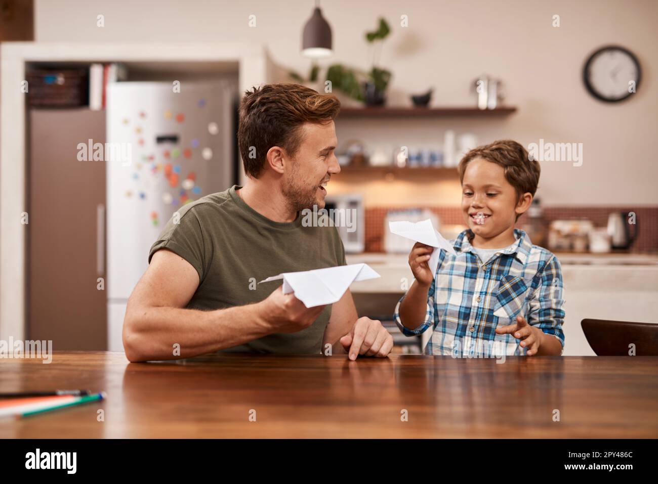 Are you ready to take off. a man and his young son playing with paper ...