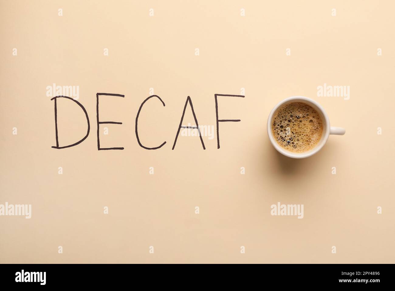 Cup of aromatic coffee and word Decaf on beige background, top view ...