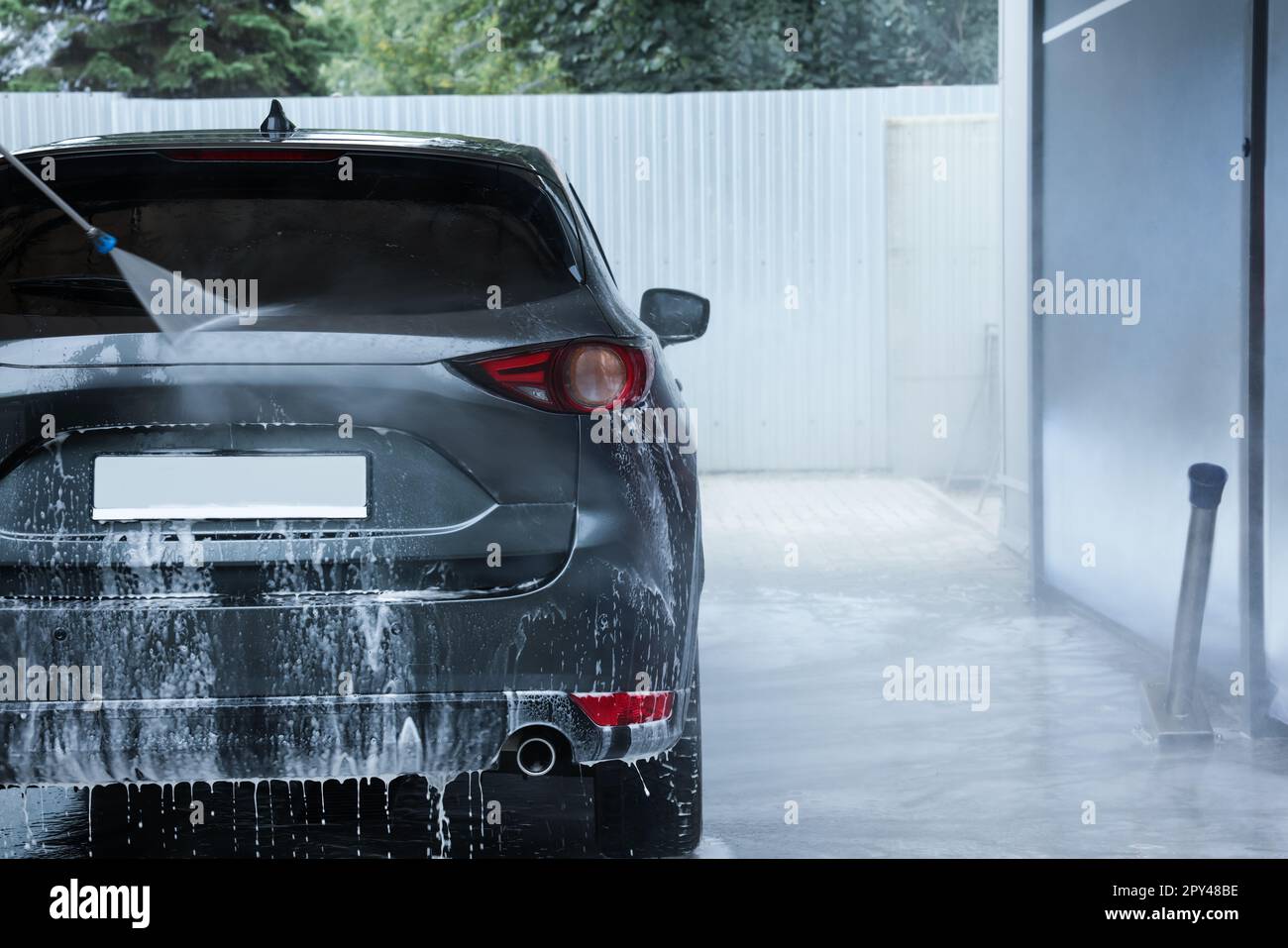Washing auto with high pressure water jet at outdoor car wash Stock ...