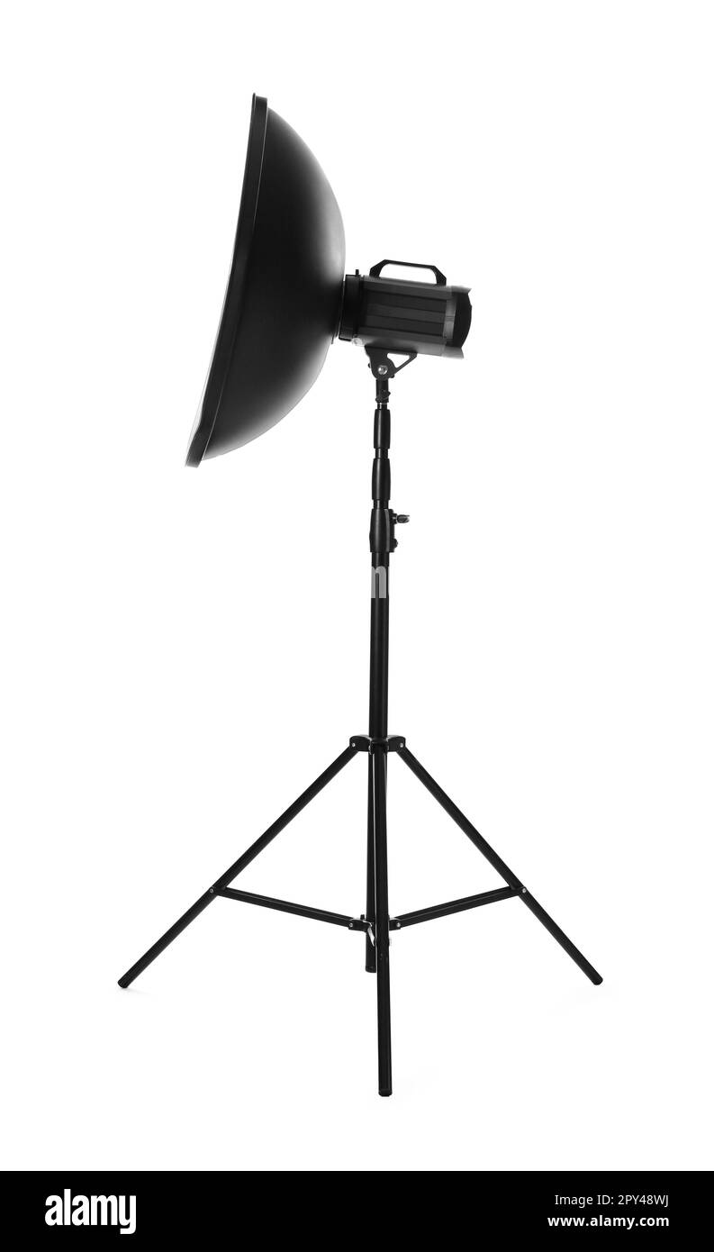 Studio flash light with reflector on tripod against white background ...