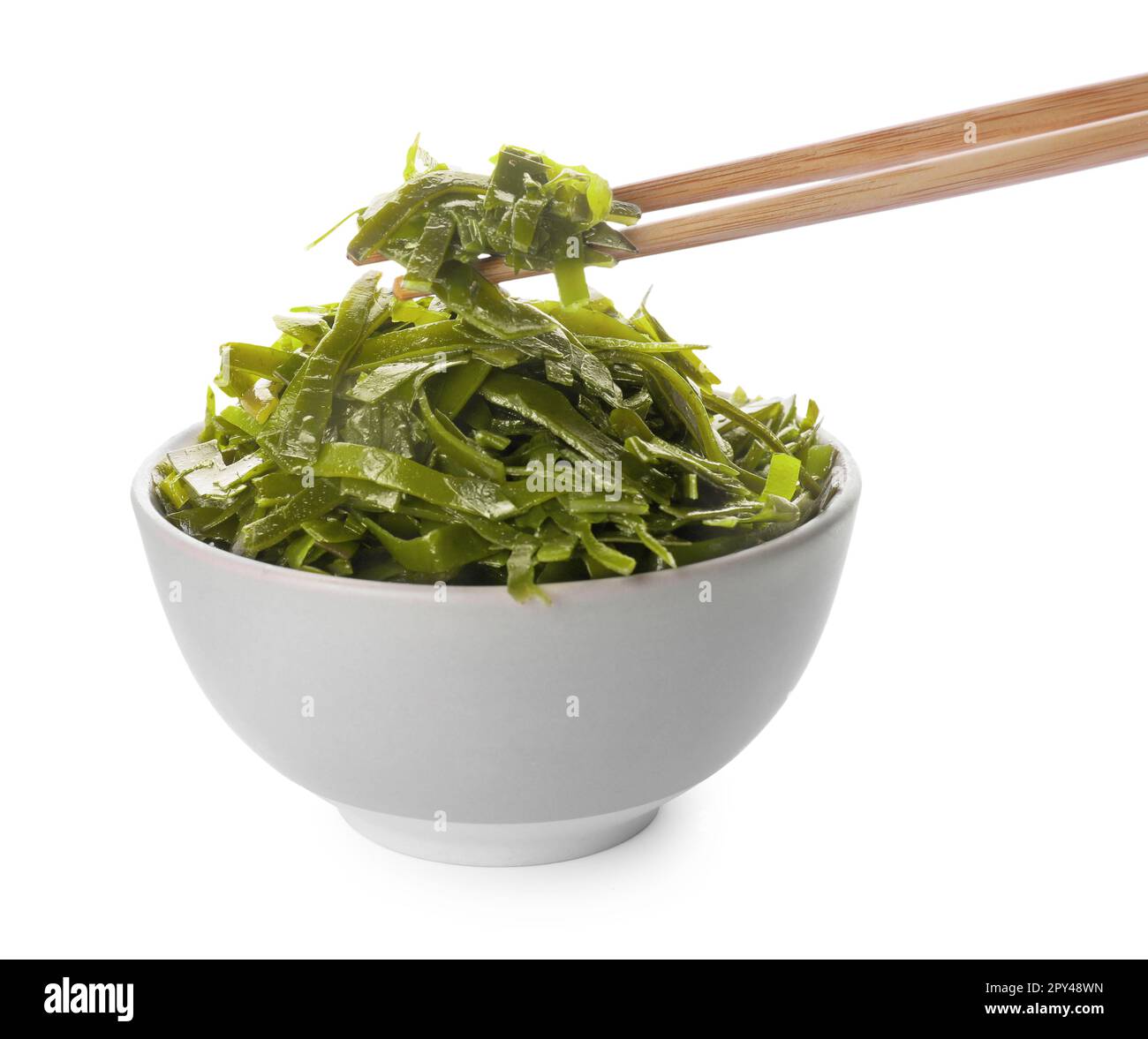Fresh laminaria (kelp) seaweed in bowl and chopsticks on white ...