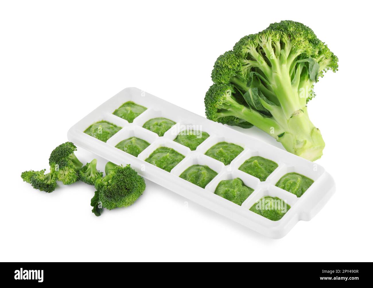 Broccoli puree in ice cube tray and ingredients on white background ...