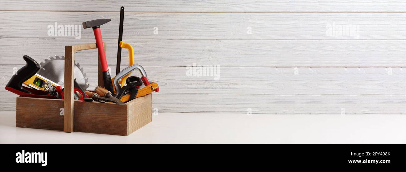 Box with carpenter's tools on white table, space for text. Banner ...