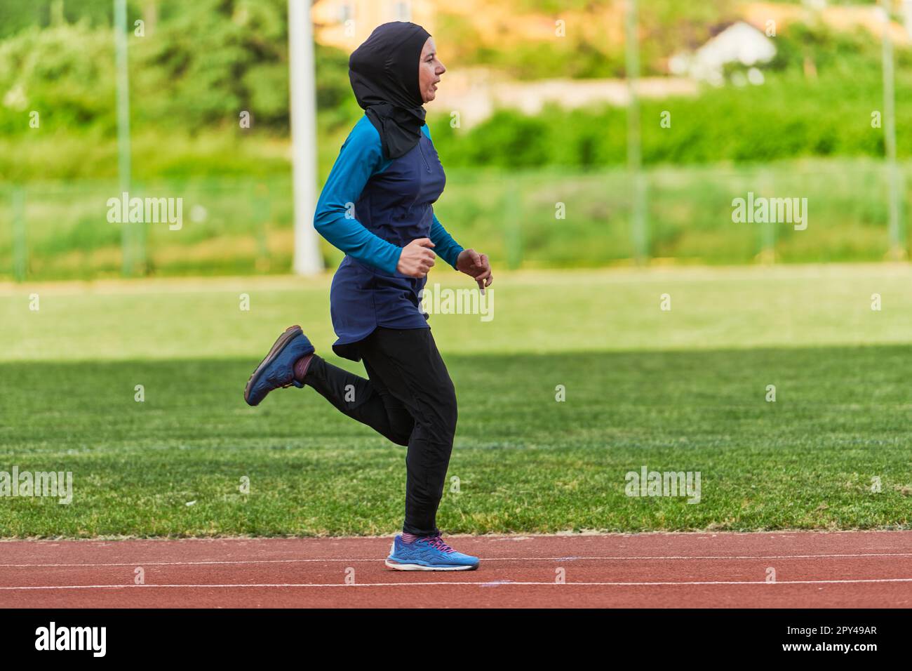 A muslim woman in a burqa sports muslim clothes running on a marathon ...