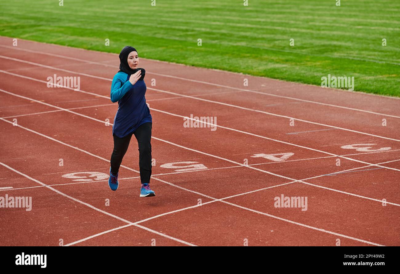A muslim woman in a burqa sports muslim clothes running on a marathon ...