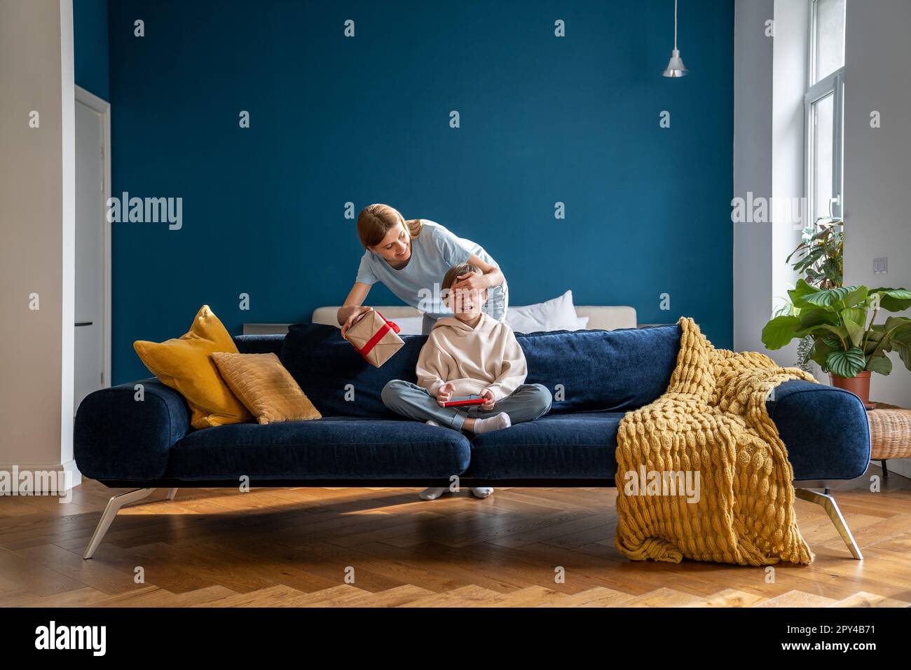 Young happy loving mother closing eyes of child son congratulating ...