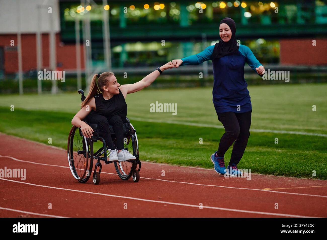 A Muslim woman wearing a burqa supports her friend with disability in a ...