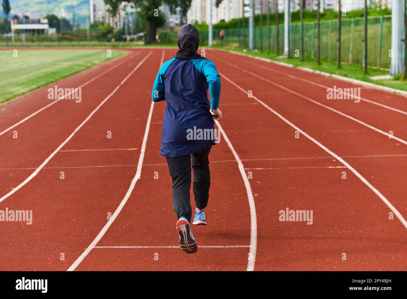 A muslim woman in a burqa sports muslim clothes running on a marathon ...