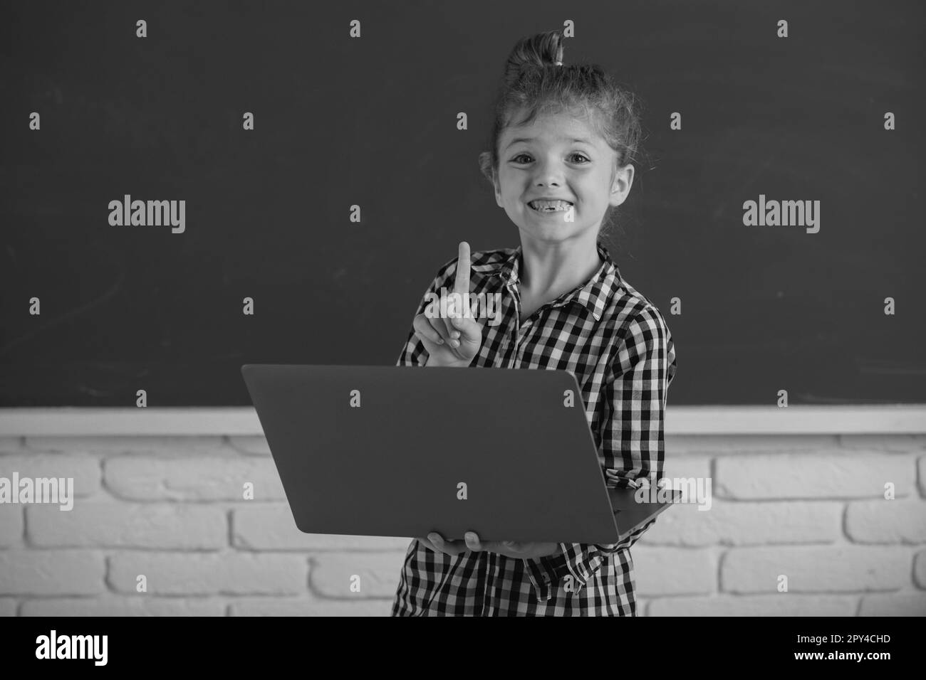Cute little child girl using laptop computer, kid studying through ...