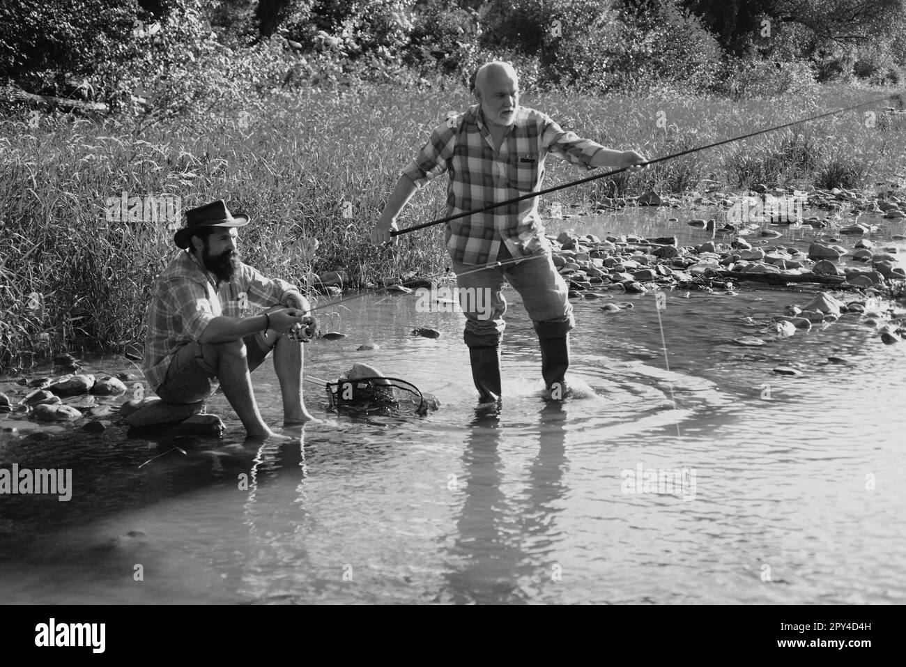 Two men friends fishing. Flyfishing angler makes cast, standing in ...