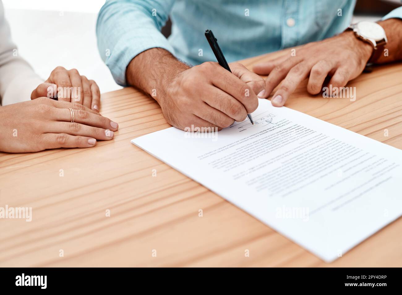 Signing on the dotted line. two unrecognizable young business ...