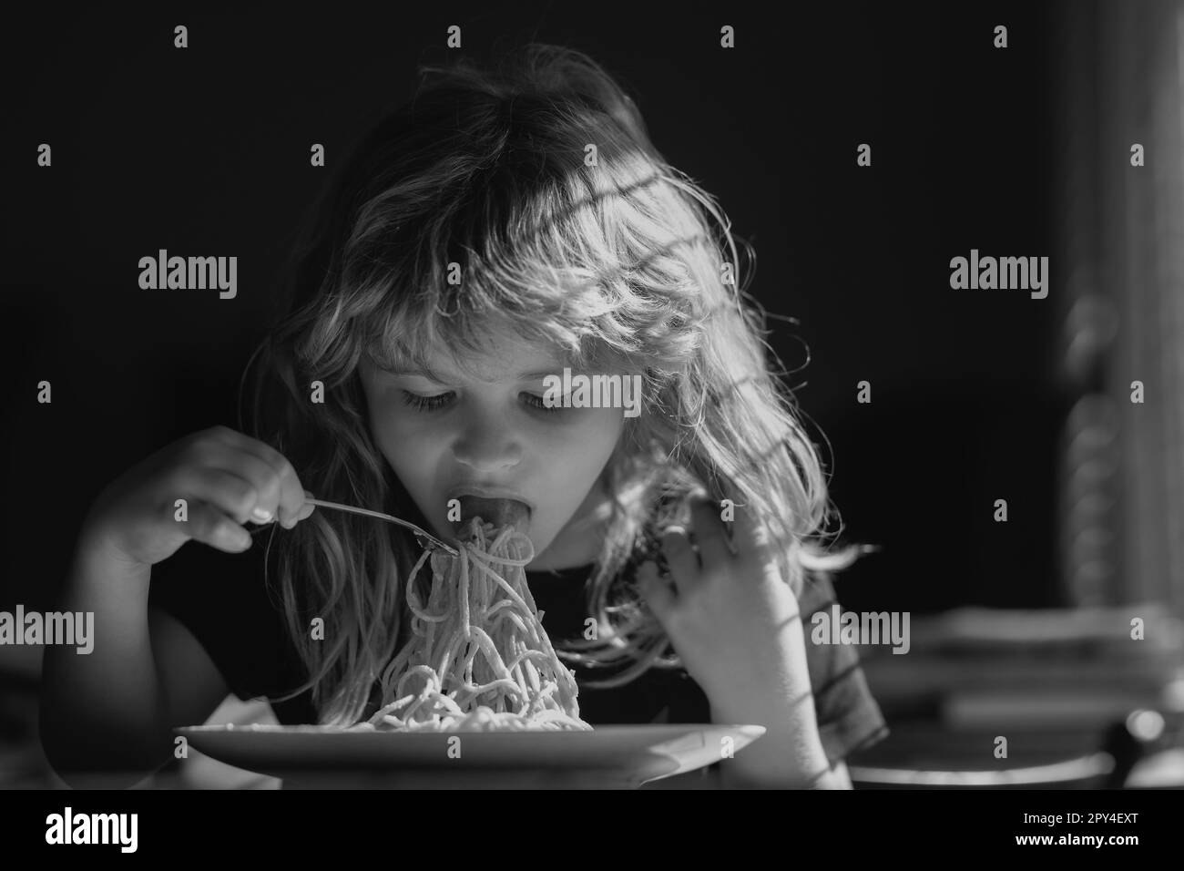 Cute child eats food itself with spoon. Cute little kid eating ...