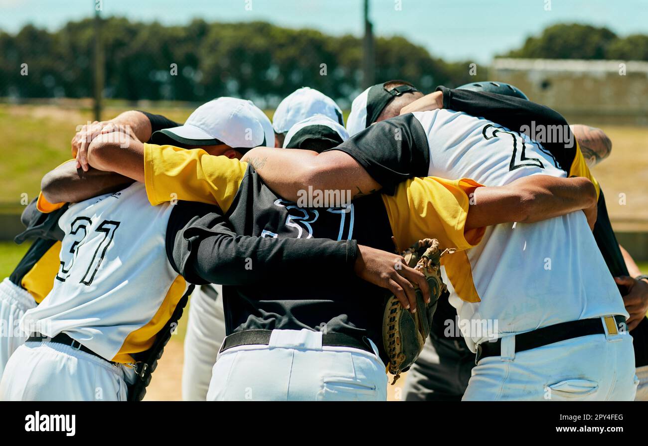 Team spirit lead us. a team of unrecognizable baseball players standing together in a huddle on ...