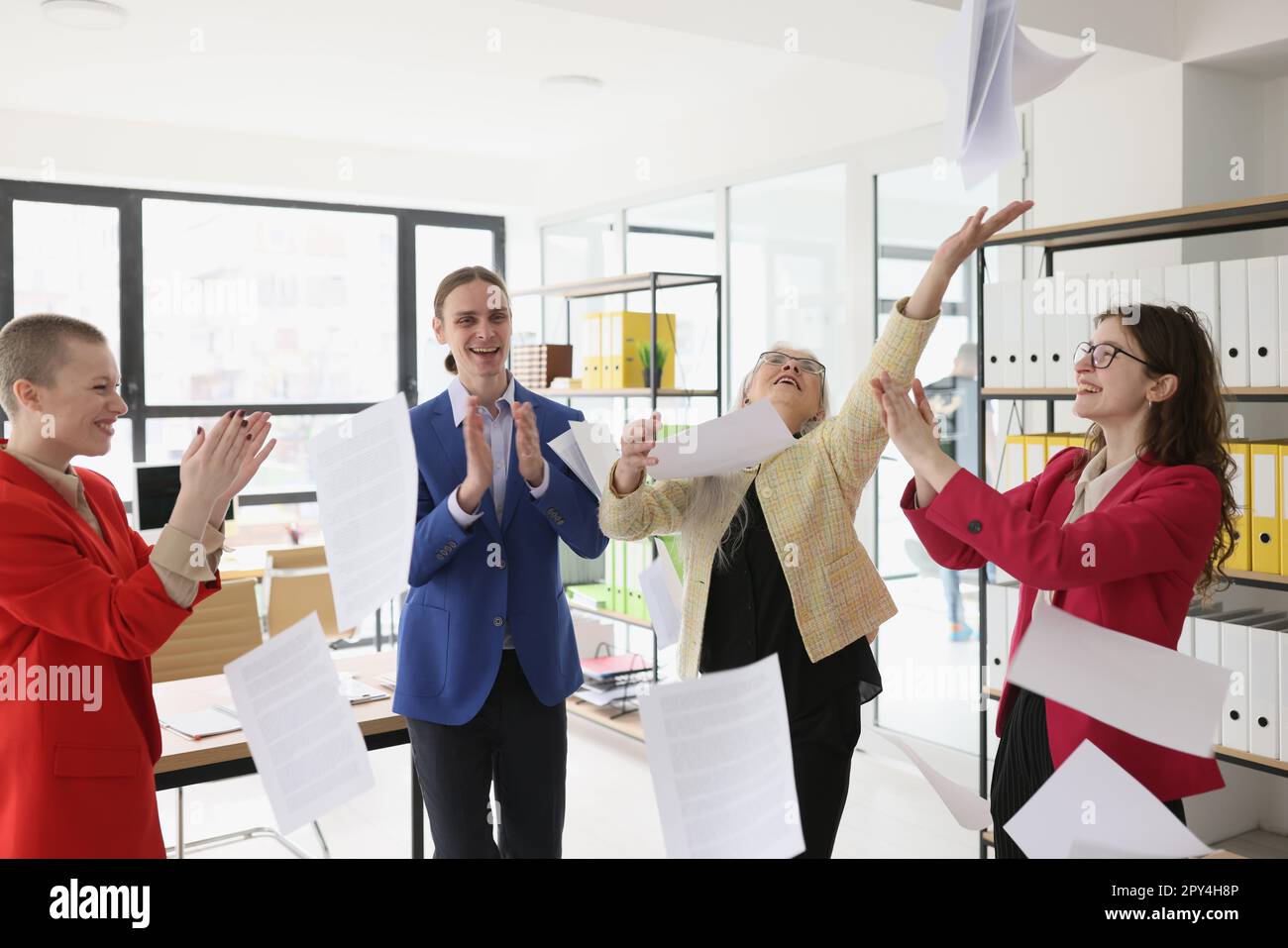 Happy colleagues throw papers clapping hands in office Stock Photo - Alamy