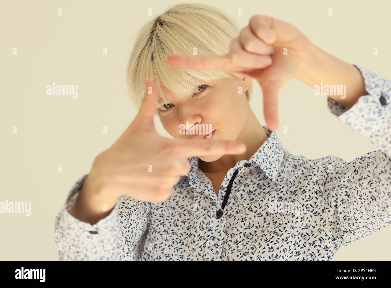 Focused woman puts fingers in shape of photo camera screen Stock Photo ...