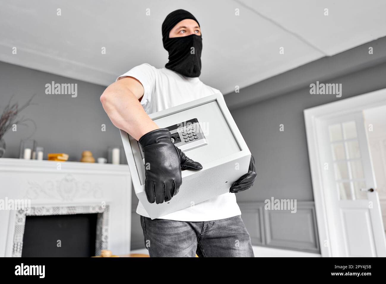 Thief with black mask stealing modern Metal safe with an electronic ...