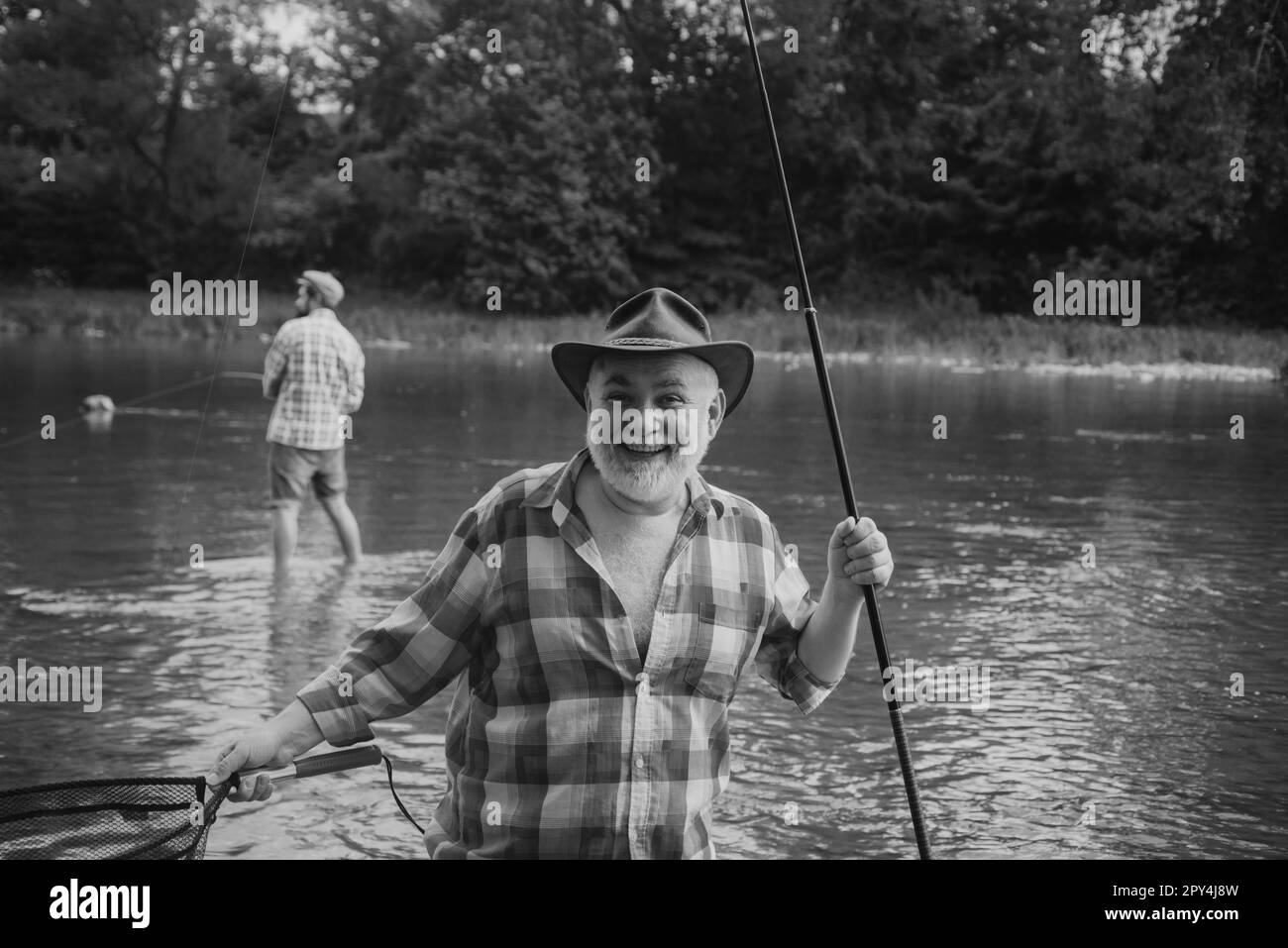 Portrait of cheerful senior man fishing. Grandfather and son fishermans ...