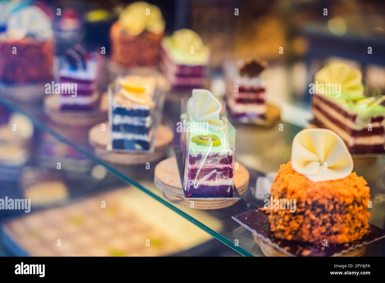 Different types of cakes in pastry shop glass display Stock Photo - Alamy