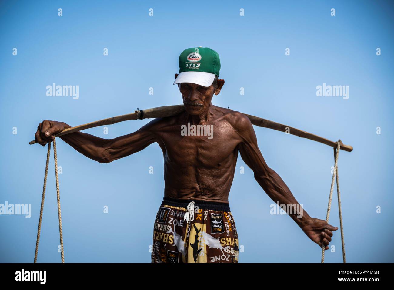 Ban Laem, Thailand. 25th Apr, 2023. A worker carries backsets full of ...