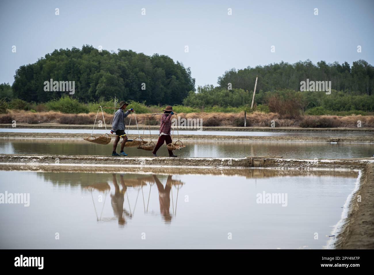 Ban Laem, Thailand. 25th Apr, 2023. Salt workers are busy carrying ...