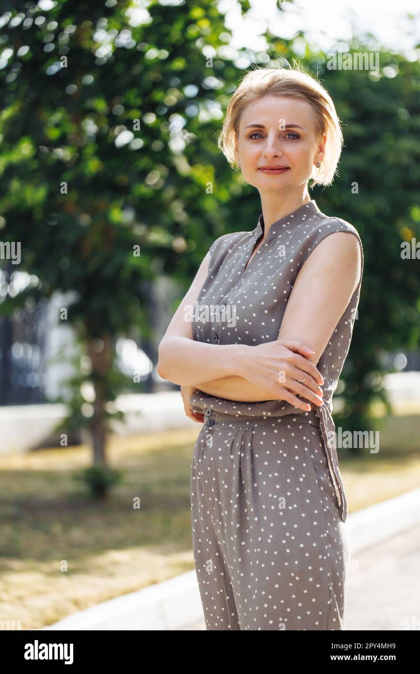 Portrait of attractive looking 40 years old woman standing half turn ...