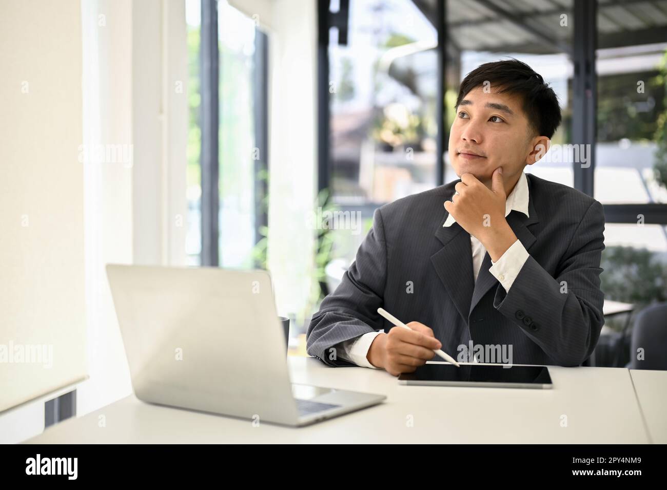 Smart and inspired millennial Asian businessman thinking, pondering and ...