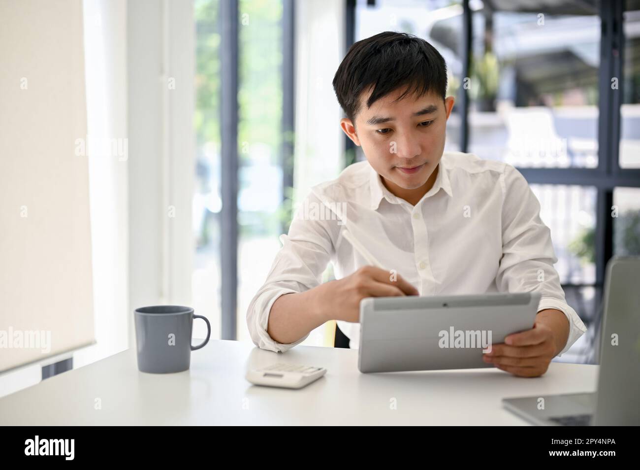 Smart and professional millennial Asian businessman or male boss using ...