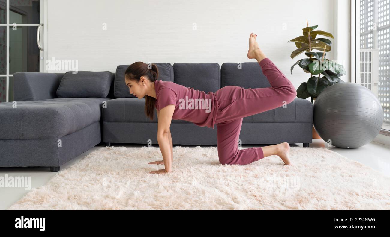 Asian Housewife Doing Vyaghrasana Pose Exercise During Home Workout