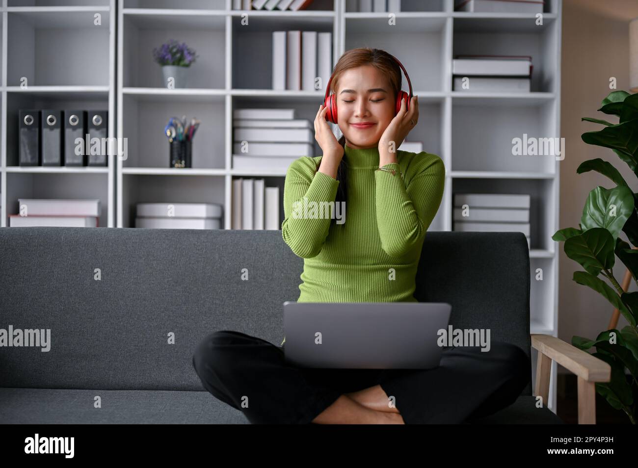 Relaxed and happy young Asian woman in casual clothes eyes closed ...