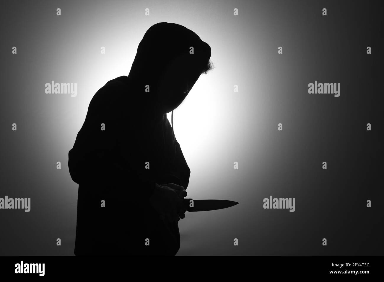 Mysterious man wearing black hoodie holding a knife to stab someone ...