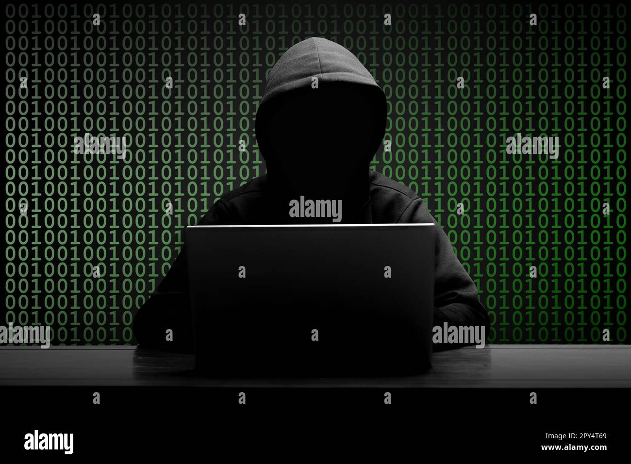 Mysterious man wearing black hoodie using laptop in the dark room ... Mysterious man wearing black hoodie using laptop in the dark room ...
