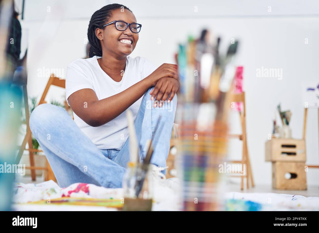 Theres nothing I enjoy more than painting. a happy young woman sitting ...