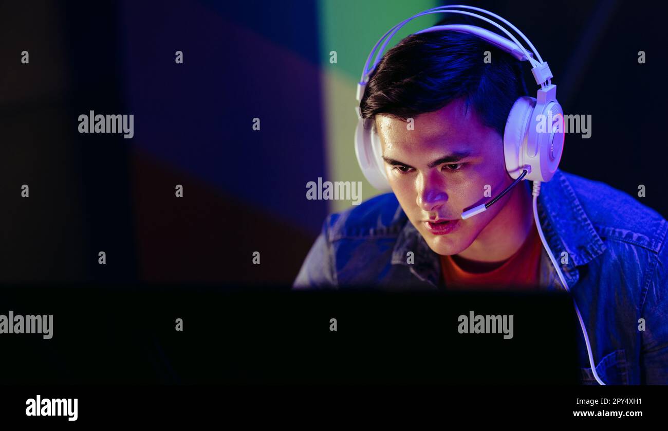 Young man looking tired at his gaming computer screen, contemplating ...