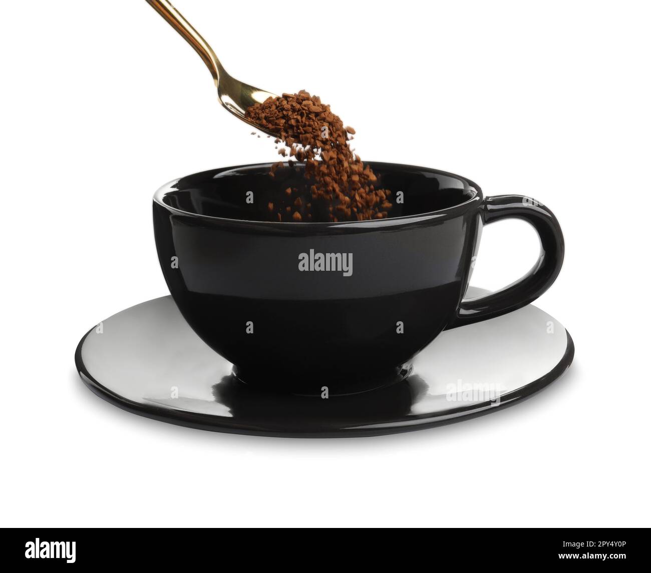 Pouring aromatic instant coffee into black cup on white background ...