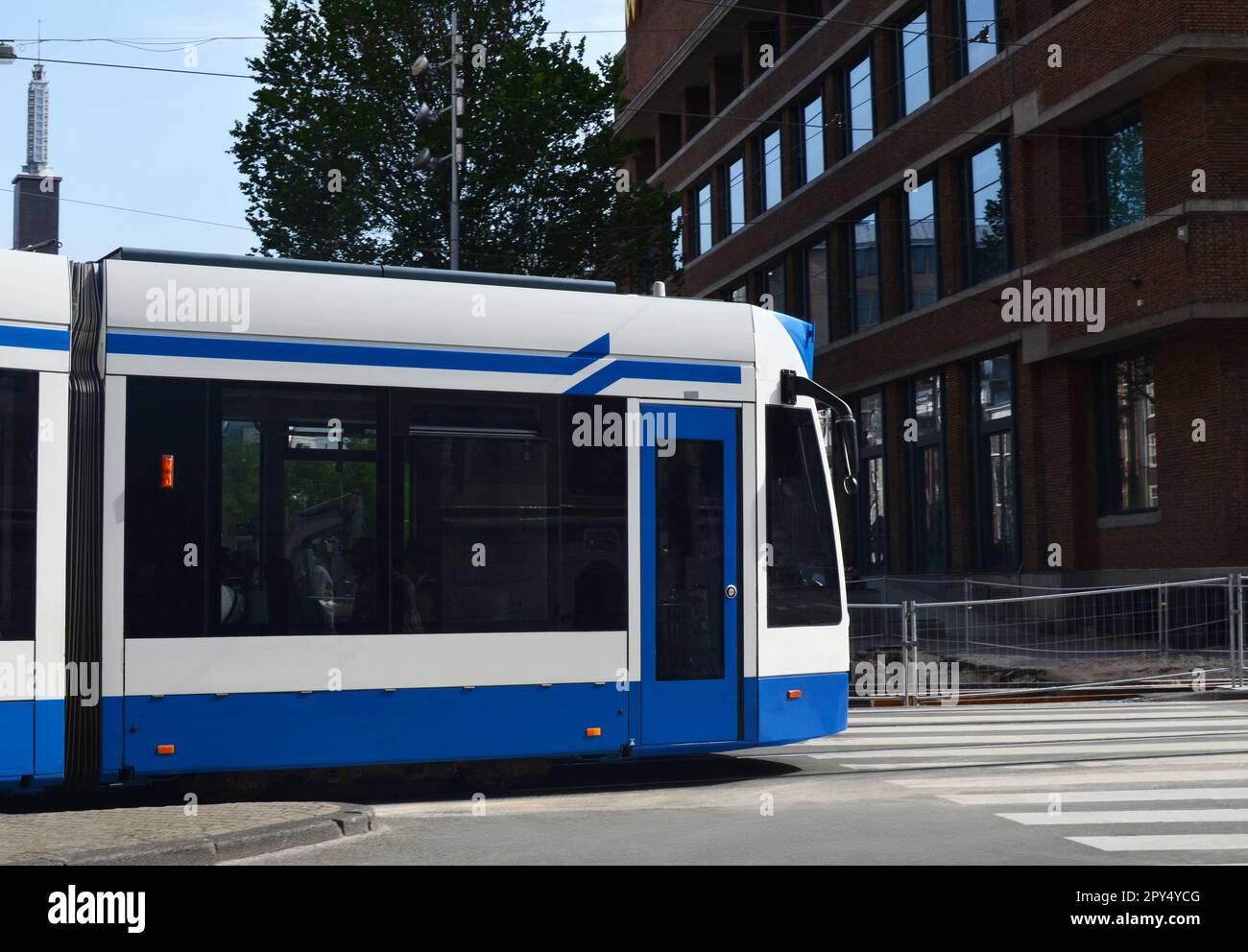 Modern tram on city street with urban architecture Stock Photo - Alamy