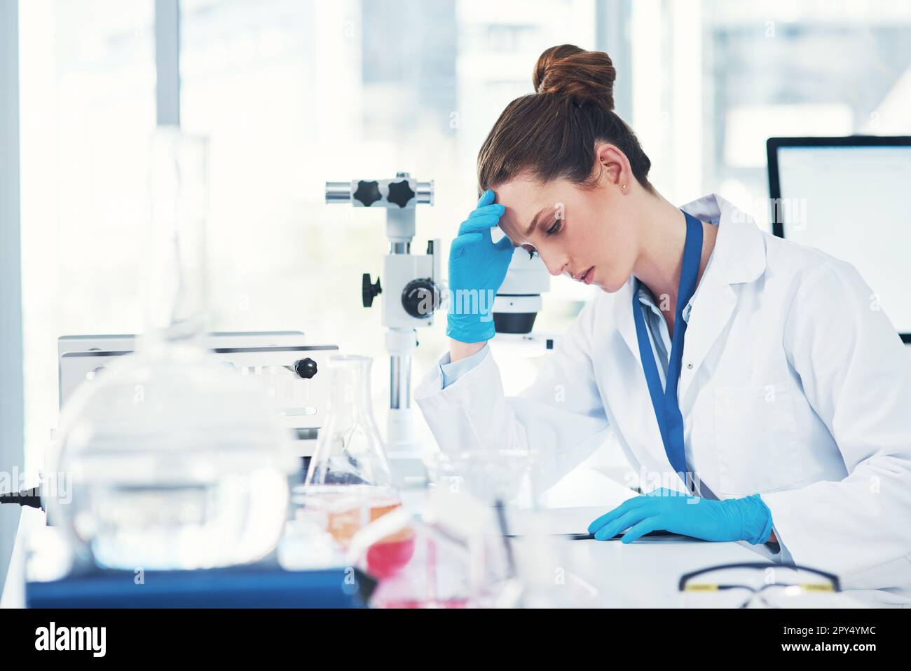Why is this so difficult. a tired young female scientist making notes ...