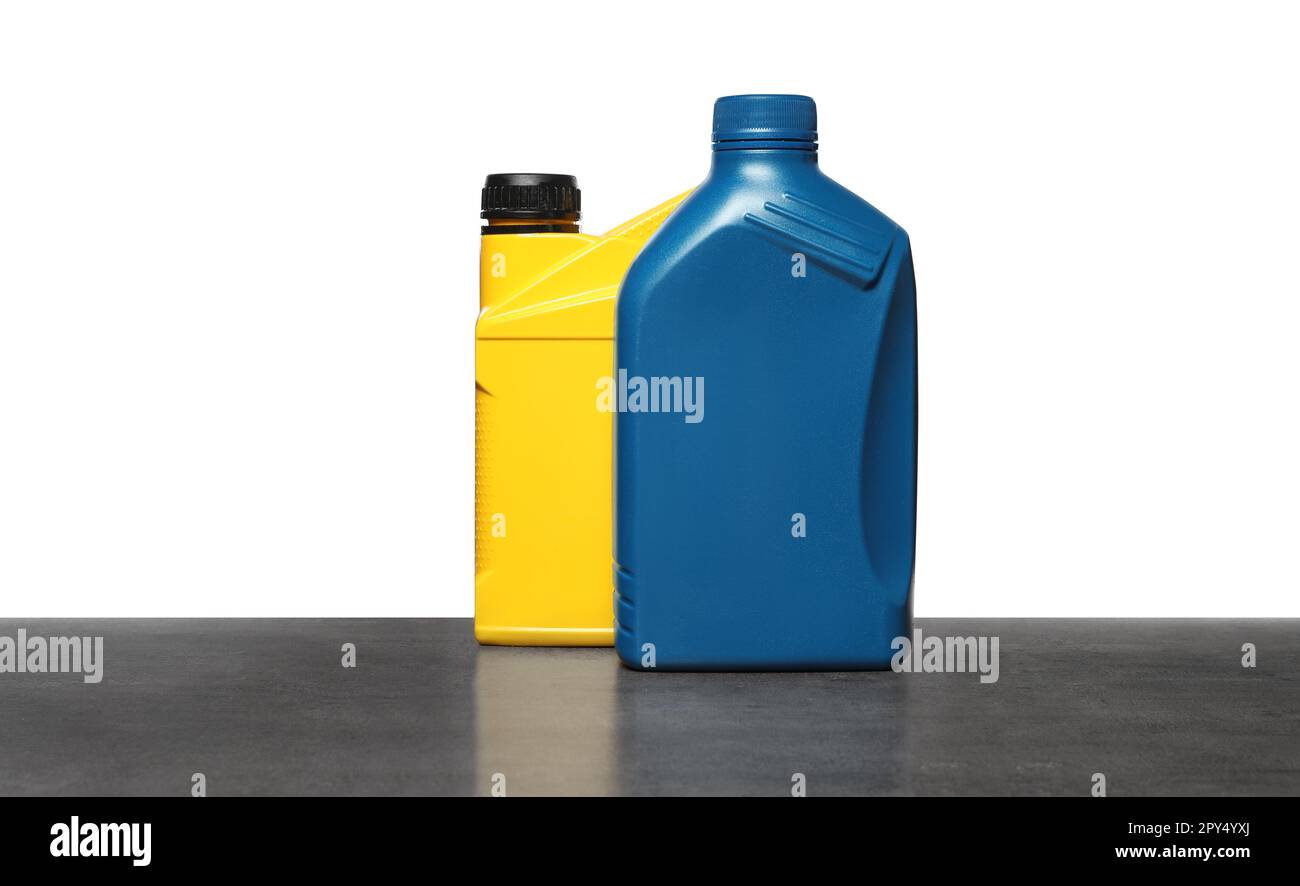 Motor oil in different containers on grey table against white ...