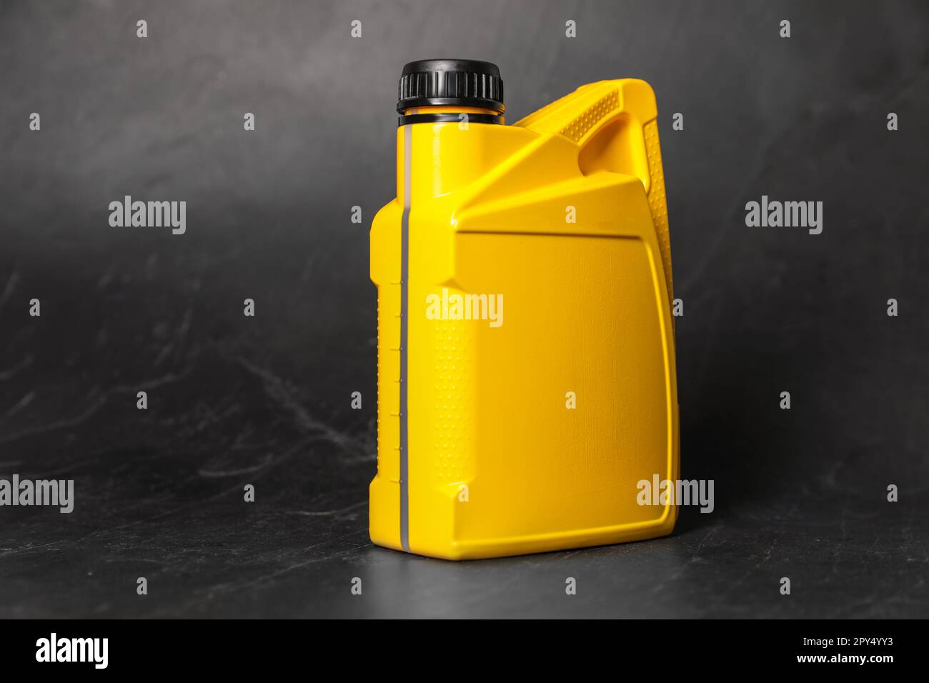 Motor oil in yellow canister on black background Stock Photo - Alamy