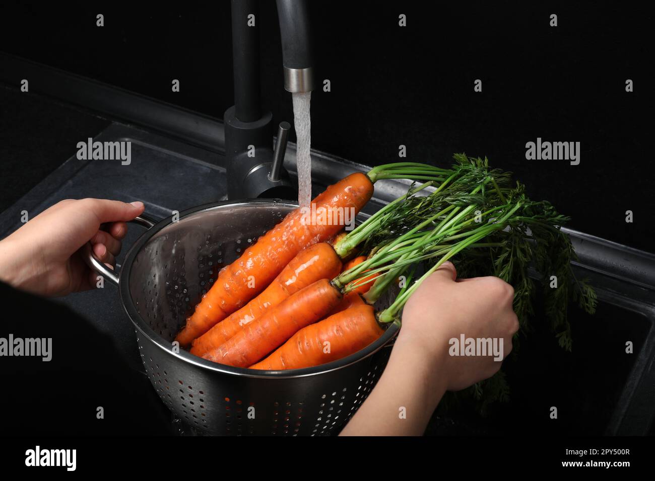 Woman washing fresh carrot under hi-res stock photography and images ...