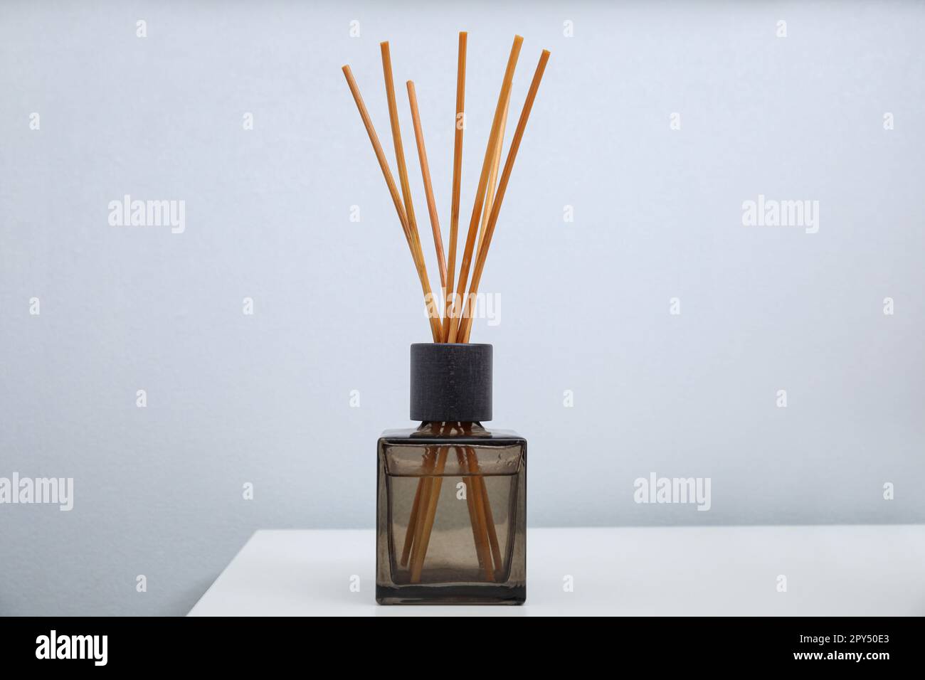Aromatic reed freshener on table near white wall Stock Photo - Alamy