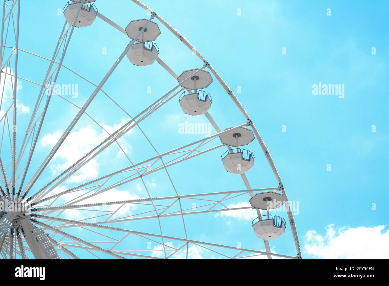 Large white observation wheel against blue cloudy sky, low angle view ...