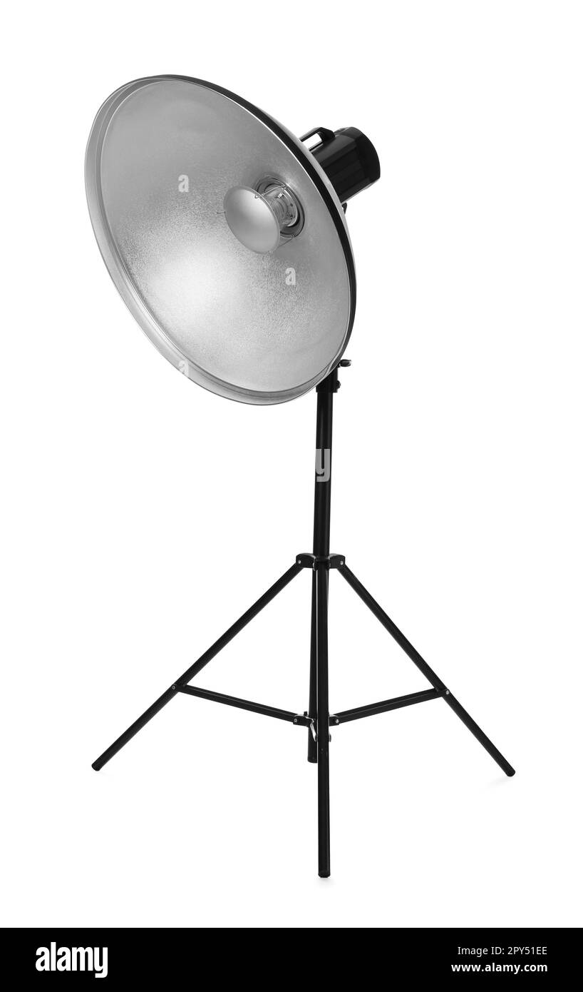 Studio flash light with reflector on tripod against white background ...