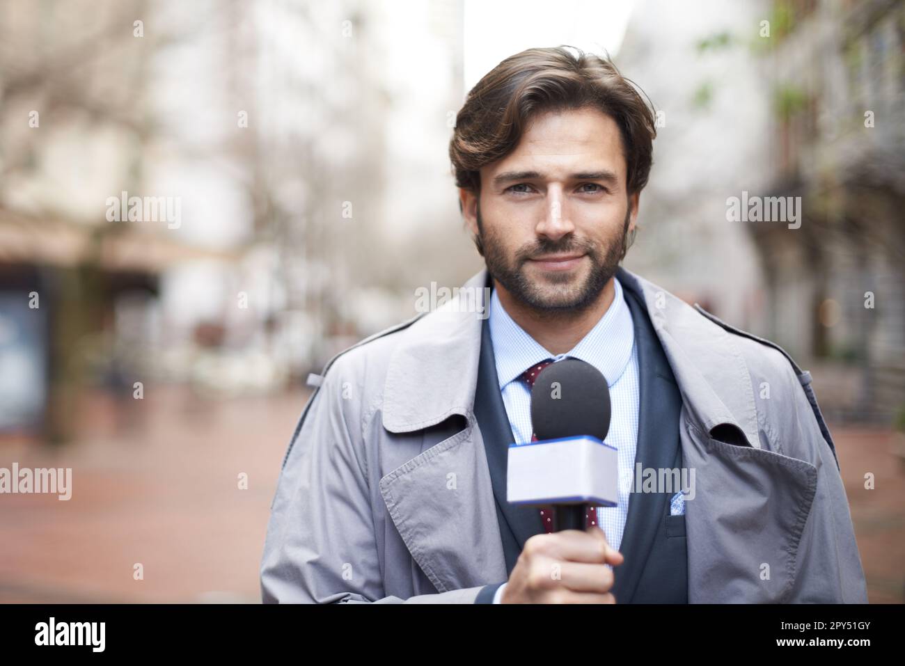Portrait, broadcast and a man with a microphone in the city for an interview or tv journalist ...