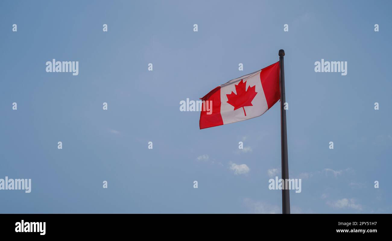 Flag of Canada flying against a blue sky Stock Photo - Alamy