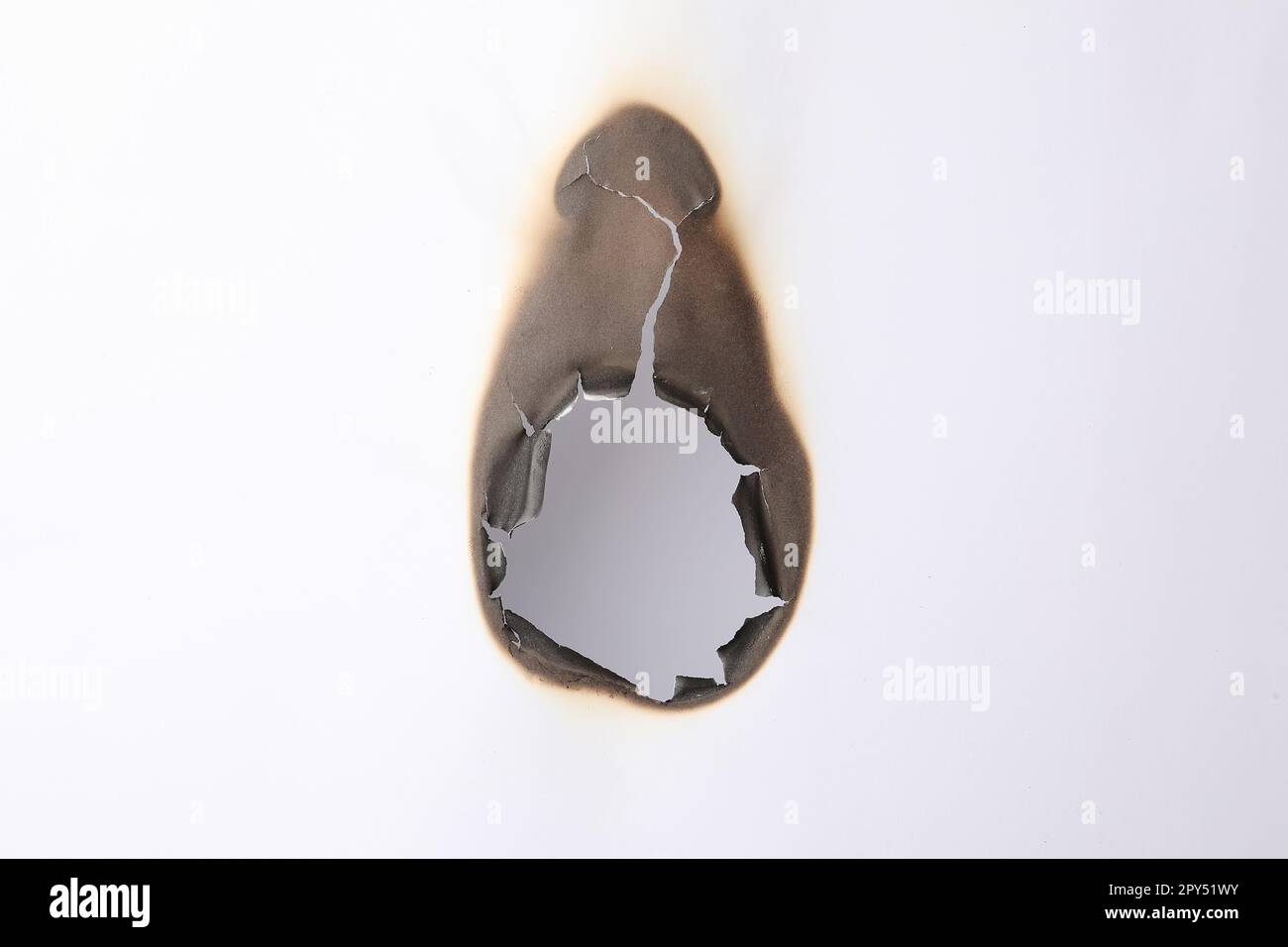 Burnt hole in paper on white background Stock Photo - Alamy