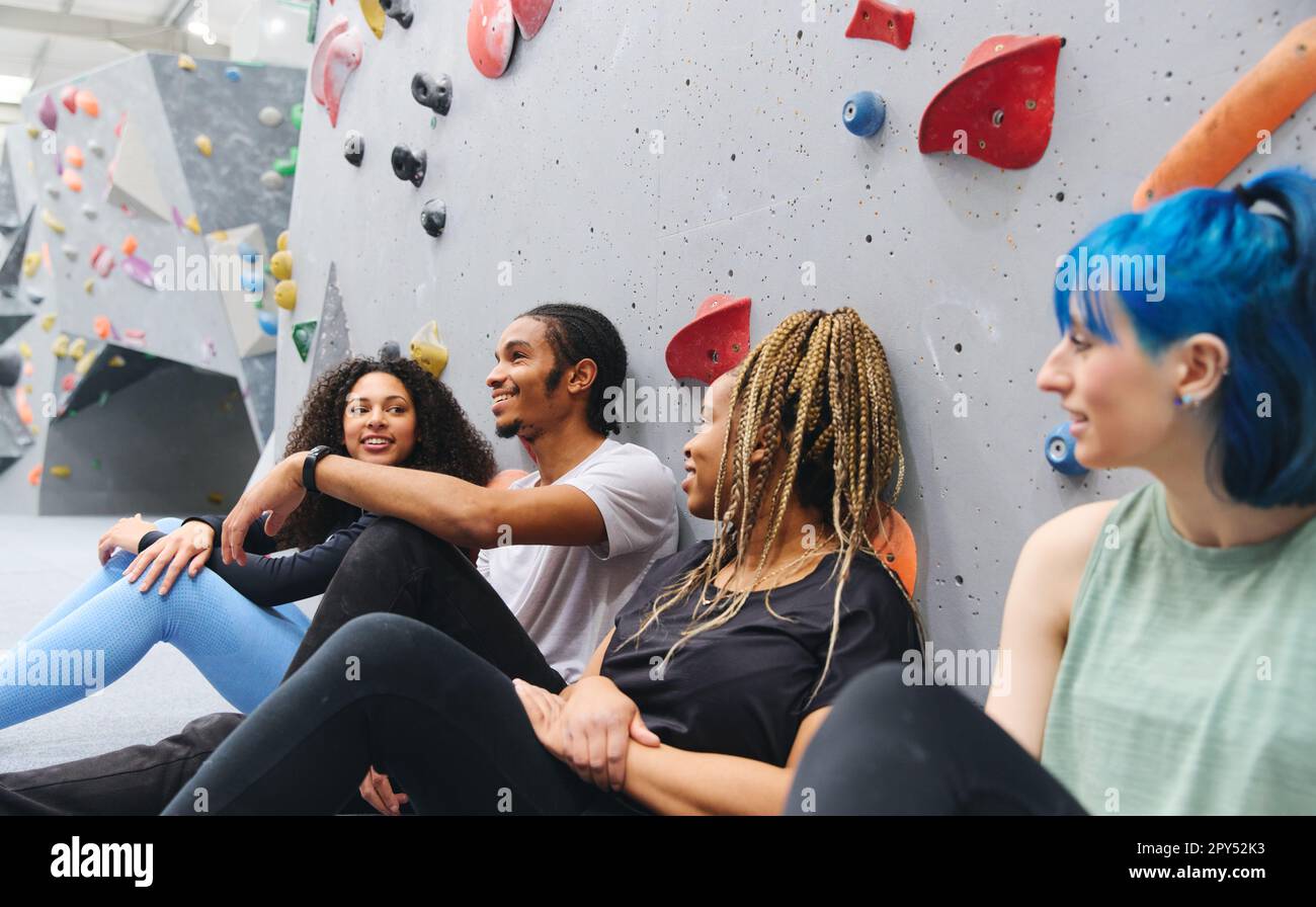 Group of friends sitting on floor taking a break after exercise at ...
