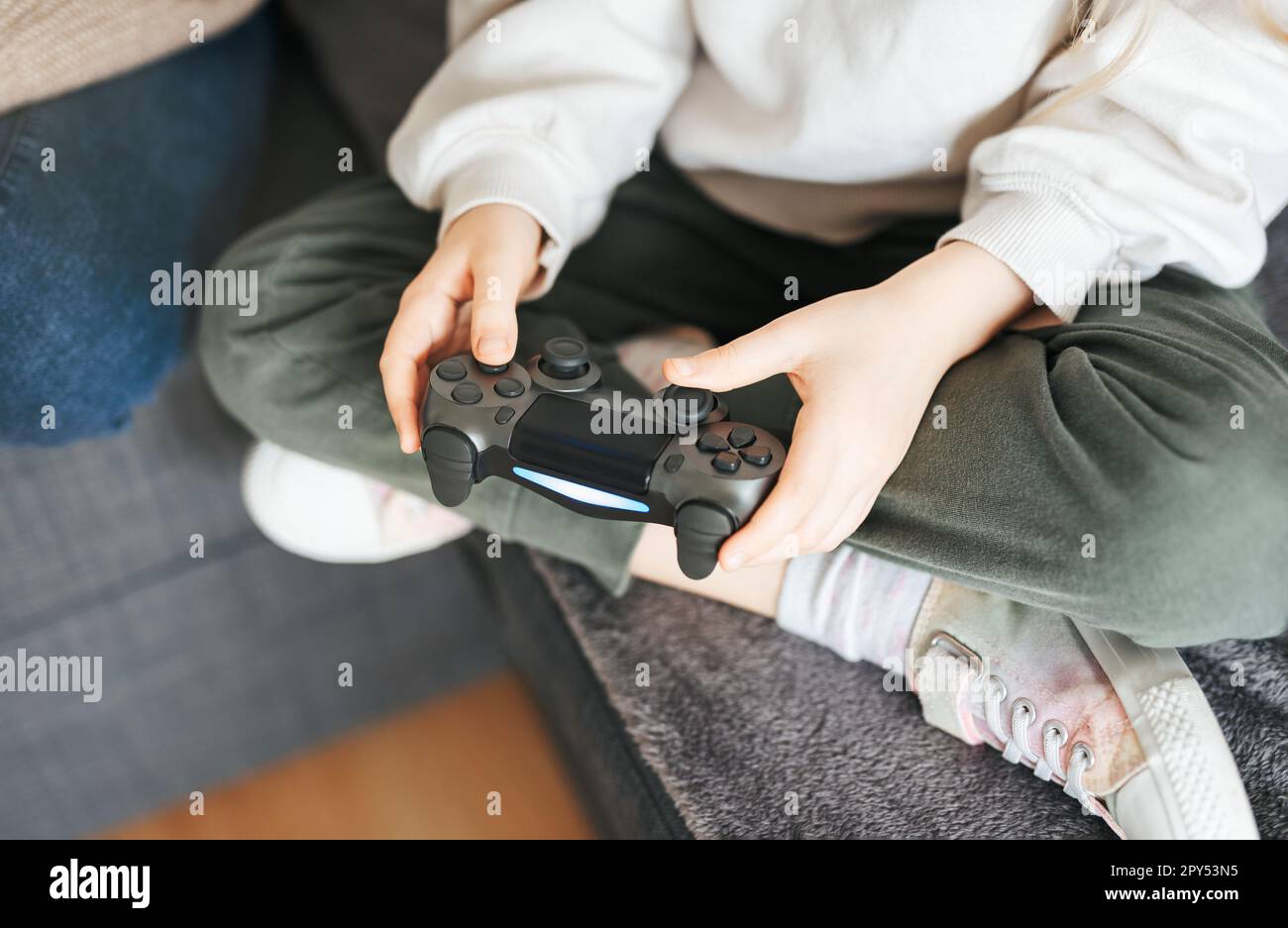 A little girl holding game controller playing video games Stock Photo ...