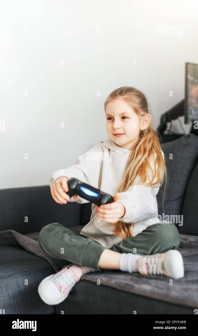 A little girl holding game controller playing video games Stock Photo ...