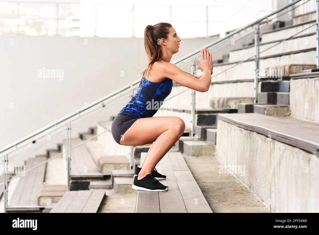 Shes hitting new levels. Full length shot of an attractive young female athlete working out on a ...