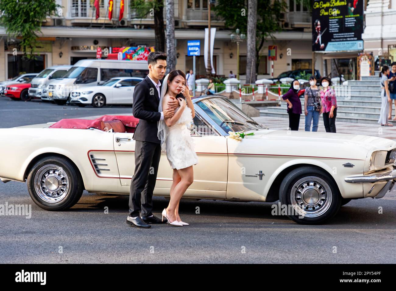 Bride and groom posing with 1967 Ford Mustang convertible used as ...